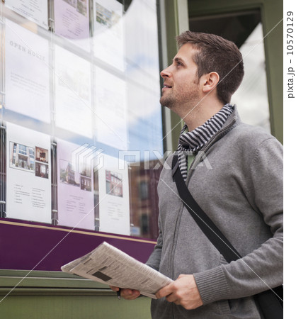 Man with newspaper looking at advert displayの写真素材 [10570129] - PIXTA