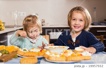 Two little girls enjoying pastry with creamの写真素材 [19957032] - PIXTA