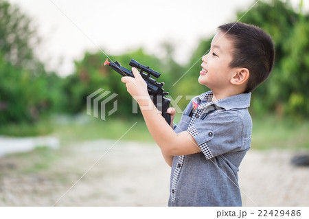 little asian boy playing with a toy gunの写真素材 [22429486] - PIXTA