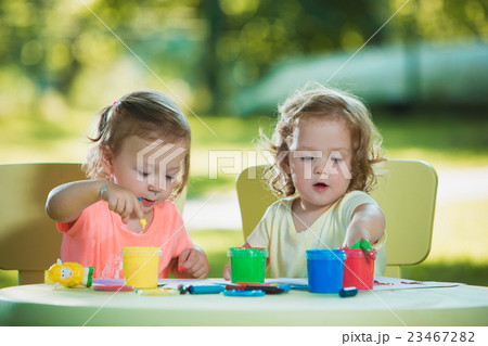 Two-year old girls painting with poster paintingsの写真素材 [23467282] - PIXTA