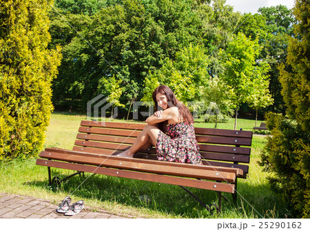 young girl sitting on a park benchの写真素材 [25290162] - PIXTA