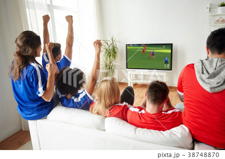 football fans watching soccer game on tv at home 38748870 PIXTA