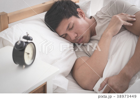 Strong man waking up late and over the alarm clockの写真素材 [38973449] - PIXTA