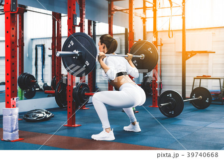 Fit beautiful girl doing squats with barbell in | materials | digitalstage
