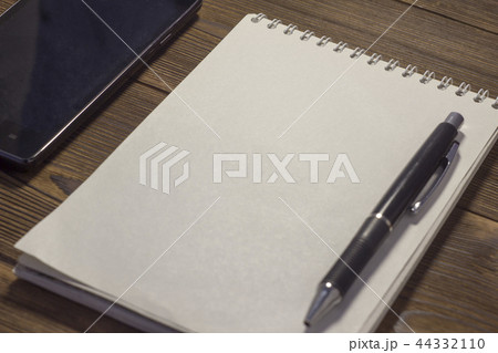 Notepad, phone, pen on a wooden backgroundの写真素材 [44332110] - PIXTA