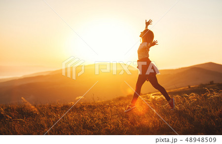 Happy woman jumping and enjoying life at sunsetの写真素材 [48948509] - PIXTA