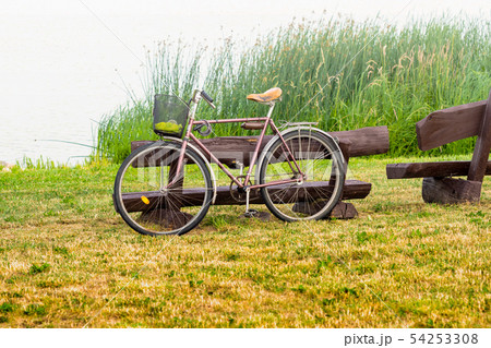 Old bicycle leaning against wooden benchの写真素材 [54253308] - PIXTA