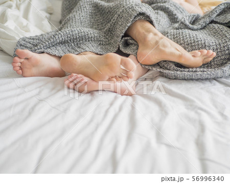 Feet of a couple under blanket. Close up view. 56996340 PIXTA