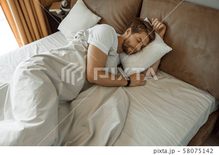 Calm man taking a nap in his badの写真素材 [58075142] - PIXTA