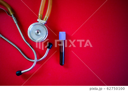 stethoscope and blood test sample on redの写真素材 [62750100] - PIXTA