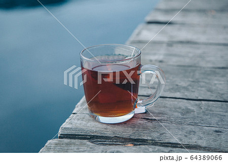 a Cup of black tea on the pier by the water...の写真素材 [64389066] - PIXTA