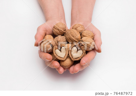 Woman's hands hold a bunch of walnuts and two...の写真素材 [76487972] - PIXTA