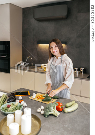 Long-haired young housewife cooking in the kitchen | materials ...