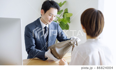バッグを査定する鑑定士と客の写真素材 [86824004] - PIXTA