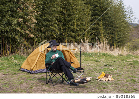 ソロキャンプ キャンプ コーヒーを飲むキャンパー 焚き火とテント アウトドア イメージ素材の写真素材 [89018369] - PIXTA