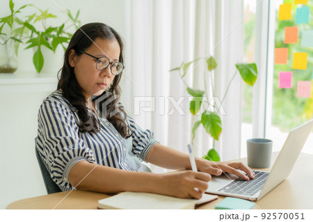 Asian woman noting down important information...の写真素材 [92570051] - PIXTA