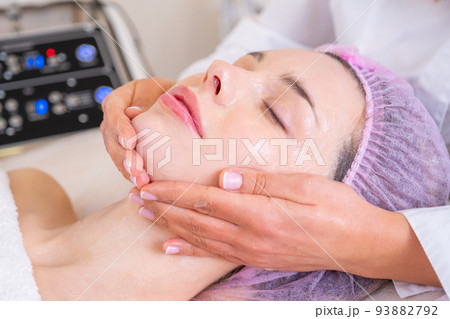 Woman in a spa salon getting face massage for...の写真素材 [93882792] - PIXTA