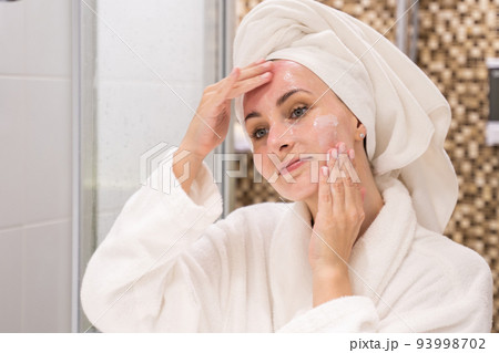 Woman takes care of face applying gel cleanser...の写真素材 [93998702] - PIXTA