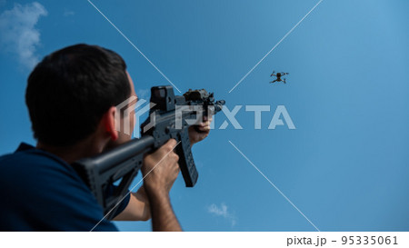 Caucasian man shoots a flying drone with a rifle.の写真素材 [95335061] - PIXTA