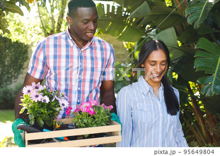 Happy diverse couple carrying flowers for...の写真素材 [95649804] - PIXTA