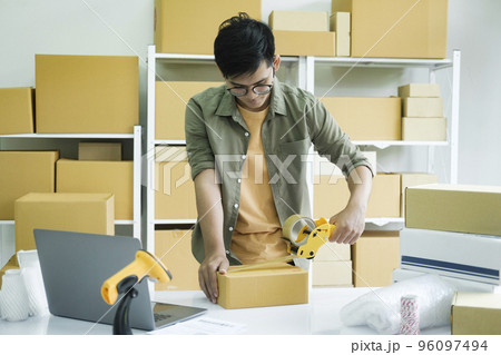 Young man packing product in box for online...の写真素材 [96097494] - PIXTA