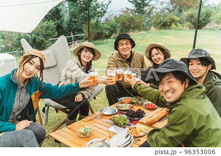 秋冬のキャンプ場で仲間と一緒にビールで乾杯するアジア人の男女の写真素材 [96353006] - PIXTA