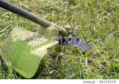 A hand-held lawn mower mows the grass in the...の写真素材 [98159226] - PIXTA