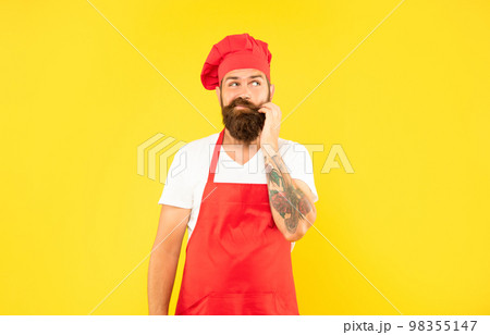 Hesitant man in red toque and apron stroking...の写真素材 [98355147] - PIXTA