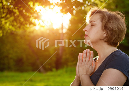 adult woman meditates with folded palms in the...の写真素材 [99050144] - PIXTA