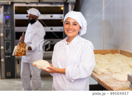 Portrait of woman baker with dough in hand in...の写真素材 [99504937] - PIXTA