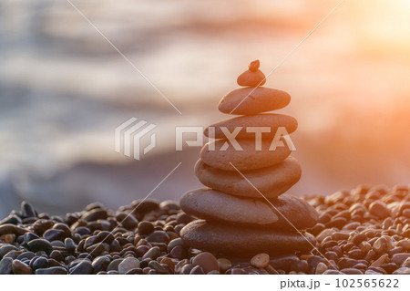Balanced rock pyramid on pebbles beach. Golden...の写真素材 [102565622] - PIXTA