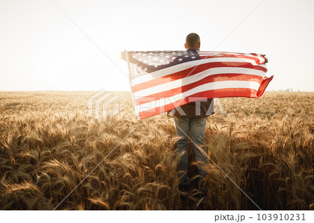Young man holding American flag on back while...の写真素材 [103910231] - PIXTA