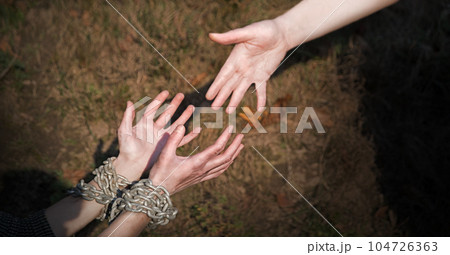 Bound hands reach out to the outstretched hand...の写真素材 [104726363] - PIXTA