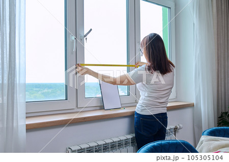 Woman measuring window with tape measure,...の写真素材 [105305104] - PIXTA
