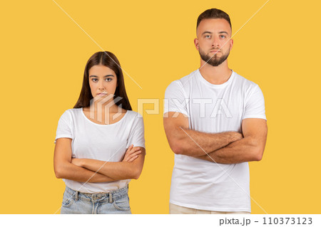 Stern-faced young couple with arms crossed in...の写真素材 [110373123] - PIXTA