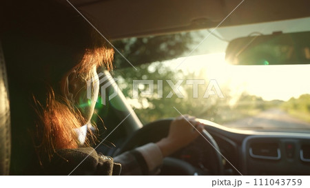Redhead woman driver driving car at sunlight...の写真素材 [111043759] - PIXTA