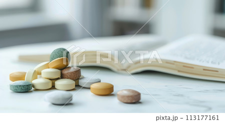 Capsules on a table with books in the background.のイラスト素材 [113177161 ...