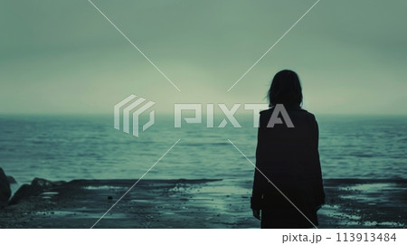 Woman standing alone on a moody ocean shoreのイラスト素材 [113913484] - PIXTA