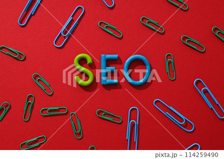 Letters and clips on red background, top viewの写真素材 [114259490] - PIXTA