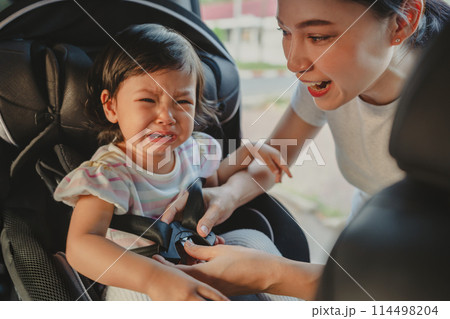 mother is fastening safety belt to crying...の写真素材 [114498204] - PIXTA