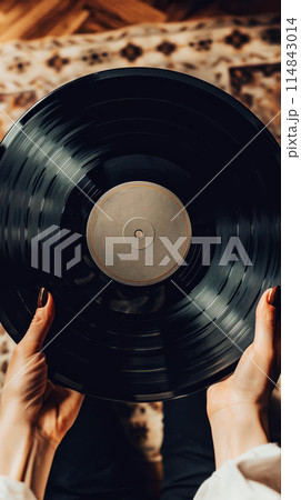 Close-up of hands holding a vinyl record....のイラスト素材 [114843014] - PIXTA
