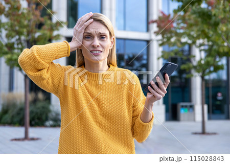 A woman in a yellow sweater looks alarmed while...の写真素材 [115028843] - PIXTA