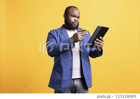 Man with frown on face while adding payment...の写真素材 [115226905] - PIXTA