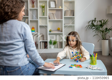Cute long-haired girl looking busy while having...の写真素材 [118450965] - PIXTA