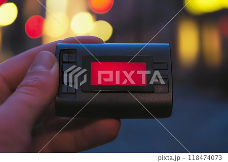 male hand holds pager while a blurred street in...のイラスト素材 [118474073 ...