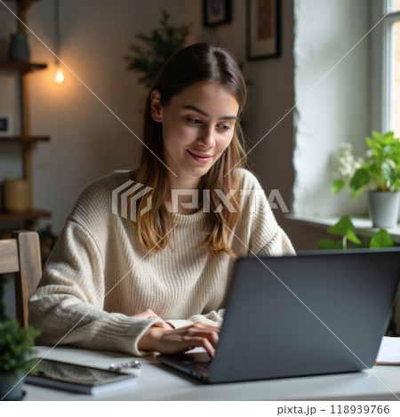 Smiling young woman in cozy sweater working on...のイラスト素材 [118939766 ...