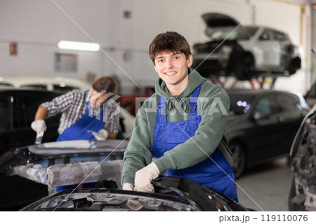 Positive young auto mechanic working in car...の写真素材 [119110076] - PIXTA