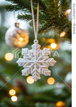 A white, ceramic snowflake ornament is hanging...のイラスト素材 [119368719 ...