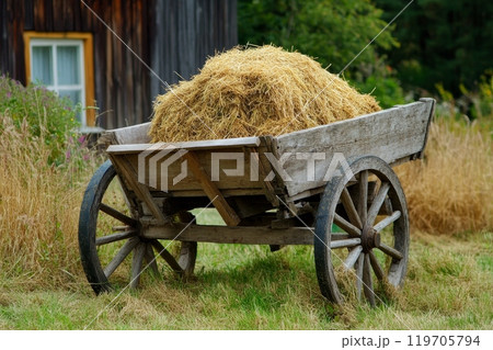 A wooden wagon overflowing with golden hay sits...のイラスト素材 [119705794 ...