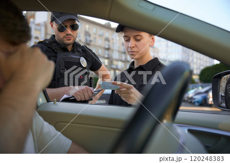 Police officers checking driving license of...の写真素材 [120248383] - PIXTA